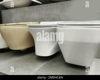 Exhibition of samples of white toilet bowls standing in a row in the ...