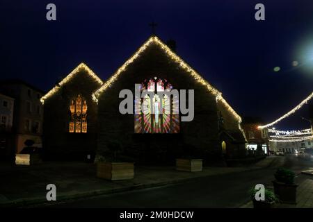 St Mary's Church, Brecon lit from within, showing stained glass windows ...