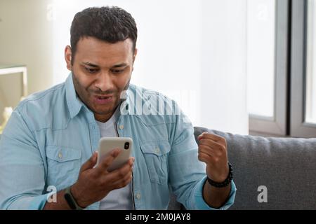 Young man holding wow text banner over yellow isolated background with ...