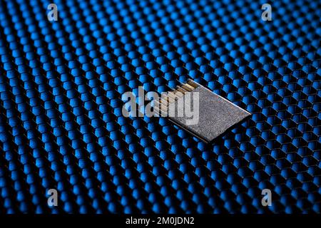 High quality black sd memory card with small gold disc on gray ...