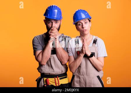 Team of contractors praying to work on building construction site ...
