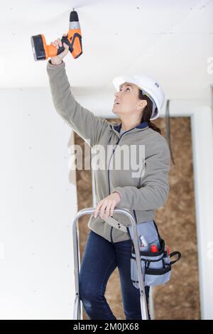 a female is drilling ceiling Stock Photo - Alamy