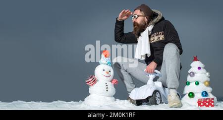 Crazy winter man on bicycle outdoor. Man with snowman on winter outdoor ...