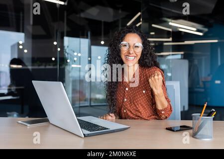 Cheerful and successful indian woman programmer at work inside modern ...