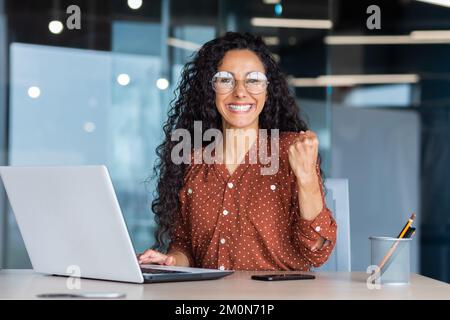 Cheerful and successful indian woman programmer at work inside modern ...
