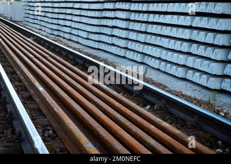 Expansion of railway lines. Train rails ready for laying and concrete ...