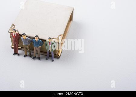 Tiny figurine of men models found beside a book Stock Photo - Alamy