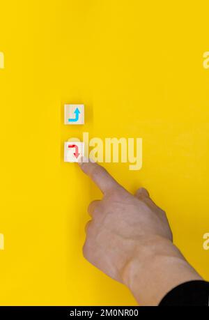The hand that selects down among the wooden blocks marked with the up ...