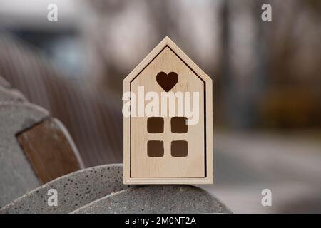 A small wooden house stands on a striped wavy stone background, a dream ...