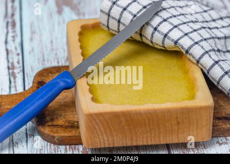 Marijuana butter with wooden mould on blue old table with checker color ...