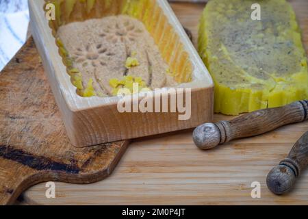 Marijuana butter with wooden mould on blue old table with checker color ...
