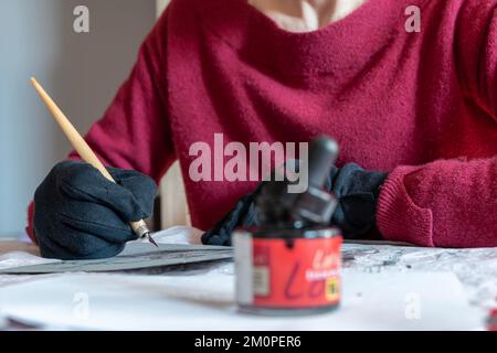 Woman draws in ink with a feather Stock Photo - Alamy