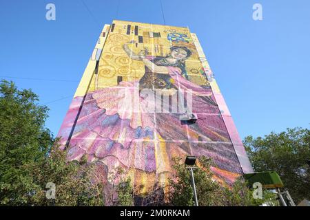 A giant painted mural on the end of a large apartment building ...