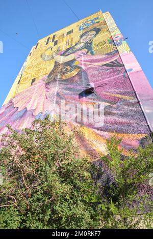 A giant painted mural on the end of a large apartment building ...