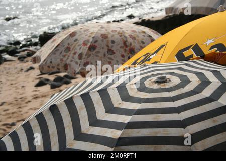 Umbrellas on the beach, N'Gor, Dakar, Senegal - silhouette of swimmer ...