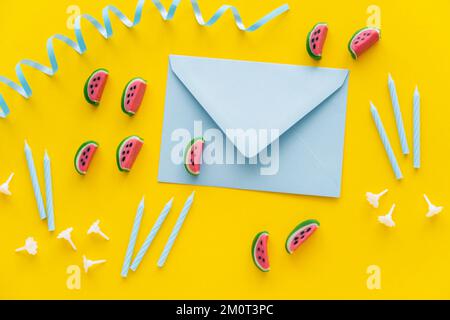 Top view of festive candles near serpentine on sprinkles on yellow ...