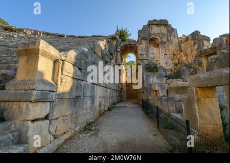 The ruins of the amphitheater and ancient rock tombs in the ancient city of Myra in Demre ...