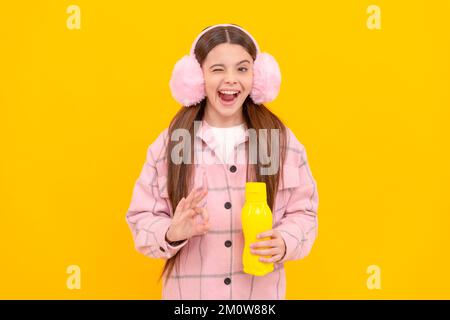 Happy winking kid hold bottled beverage product showing ring gesture ...