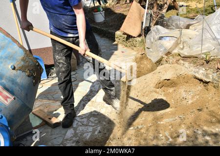 A Mason makes concrete using a concrete temperer traditionally Stock ...