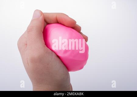 Squeezing pink balloon with hand on a white background Stock Photo - Alamy