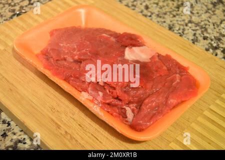 Packaged clean very fresh red raw cow meat, on cutting board Stock ...