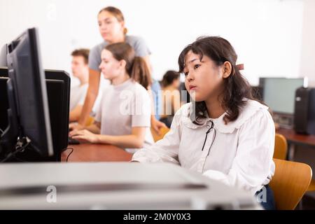Schoolgirl learning basics of programming in group course in computer ...