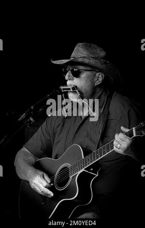 Portrait of a cheerful age guitarist with a guitar on his shoulder ...