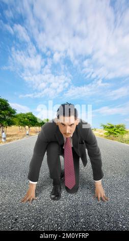 Asian businessman in start position ready to run on the street Stock ...