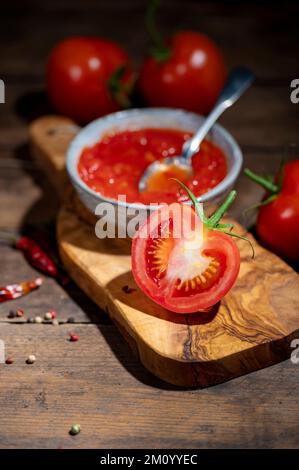 Strained tomatoes in small bowls on rustic cutting board Stock Photo ...