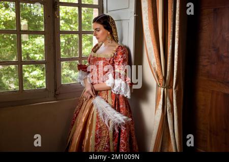 Woman wearing authentic Renaissance costome and headdress standing at ...