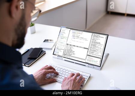 Programmer Or Coder At Office Desk Using Laptop Stock Photo - Alamy