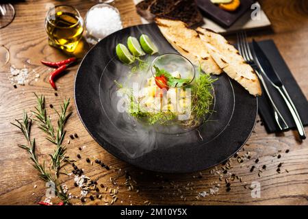 Scallop ceviche with mango, chilli and cilantro served with liquid ice ...