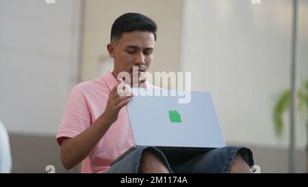 One young hispanic man shutting laptop off. Male person turning ...