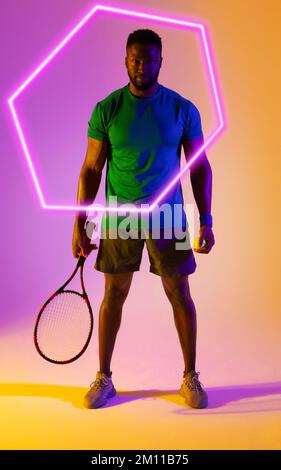Hexagon neon over confident african american young rugby player holding ...