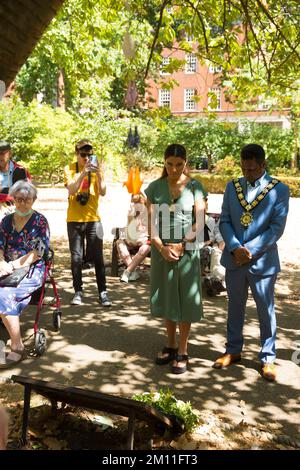Mayor of Camden, Cllr Nasim Ali, observes a silence near the cherry ...