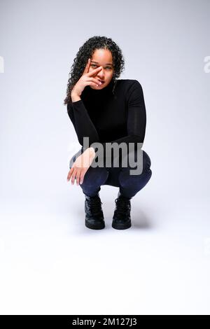 Young Multiracial Woman Squatting Facing Camera | Isolated on white ...