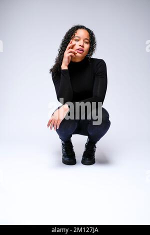 Young Multiracial Woman Squatting Facing Camera | Isolated on white ...