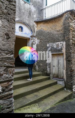 Alley in a mountain village, rainbow umbrella, Cinque Terre, Italy ...