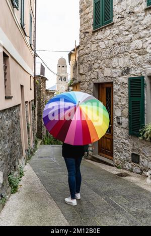 Alley in a mountain village, rainbow umbrella, Cinque Terre, Italy ...