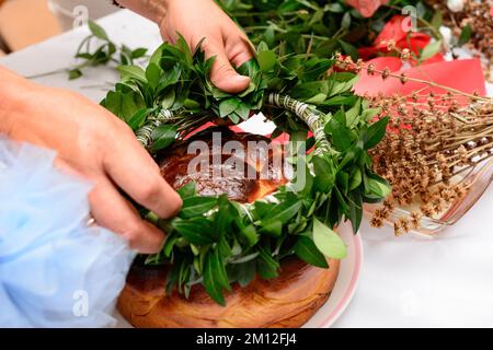 The process of weaving a periwinkle wreath, which is a traditional ...