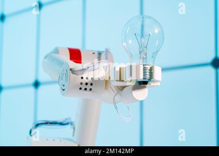 Robotic arm holding light bulb. Image concept and part of a series ...