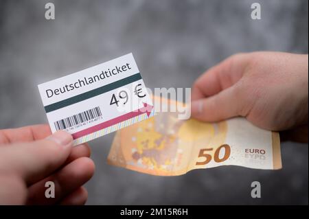 Hands exchanging proposed new germany wide 49 Euro Ticket for 50 euro ...
