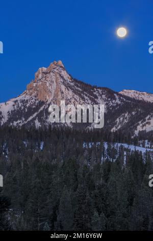 full moon setting behind ross peak in the bridger mountains in winter ...