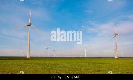 windmill turbines during winter generating electricity with a blue sky ...