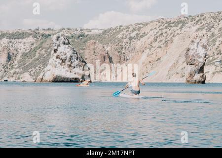 Side view foto of a man swiming and relaxing on the sup board. Sportive ...