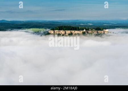 The fortress Festung Königstein is sticking out of thick fog in the ...