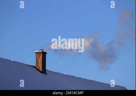 Ruderatshofen, Germany. 11th Dec, 2022. A smoking chimney stands on a ...