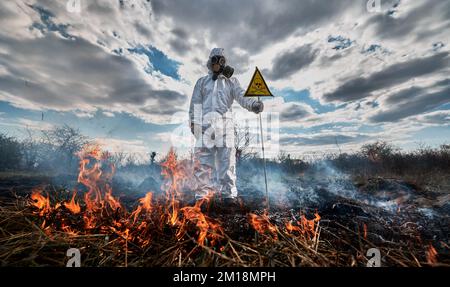 Firefighter ecologist fighting fire in field at night. Man in ...