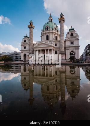 A vertical shot of the Karlskirche church near the water in Karlsplatz ...