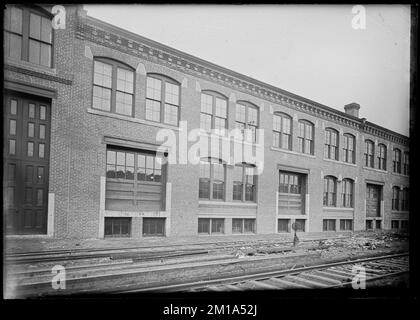 Two story warehouse along railroad spur, showing railroad car 1900-1907 ...
